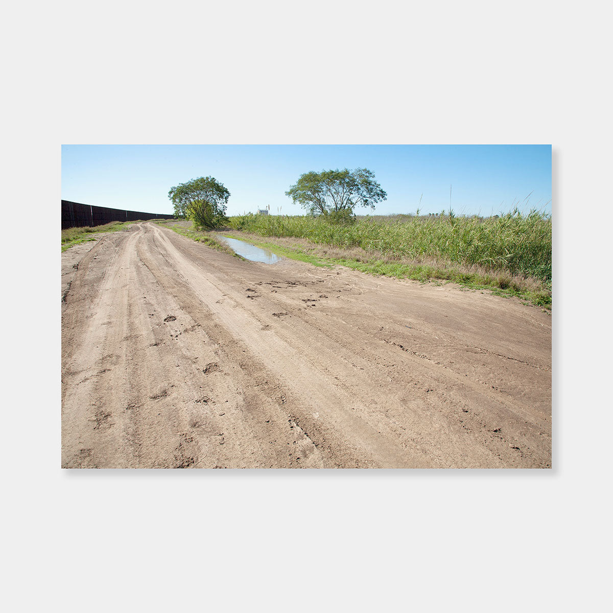 Buy 'Border Fence with migrant footprints crossing the road' by Susan ...